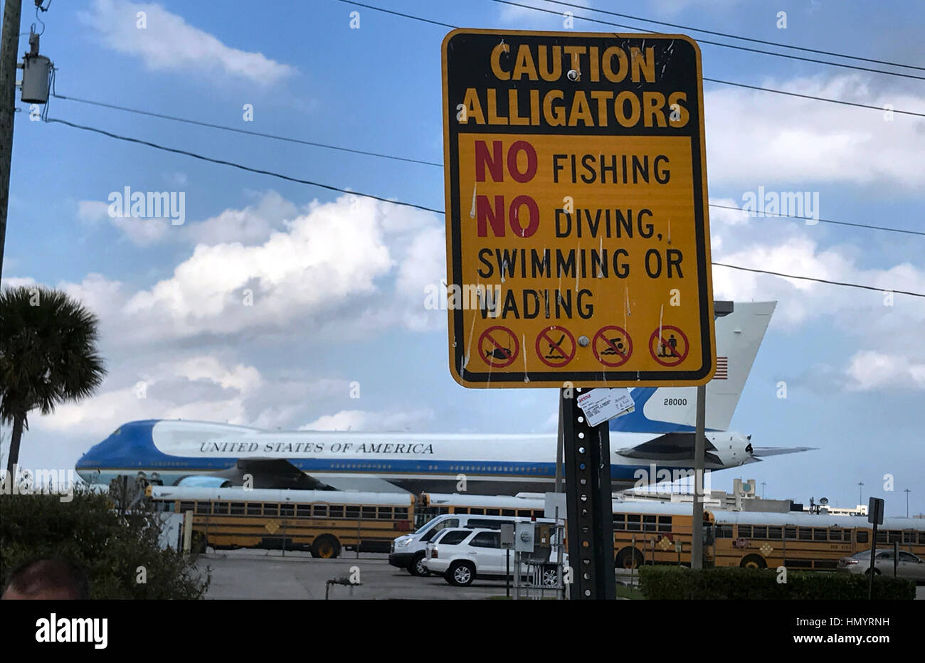 A sign cautions sightseers of alligators in a canal as they gather to ...