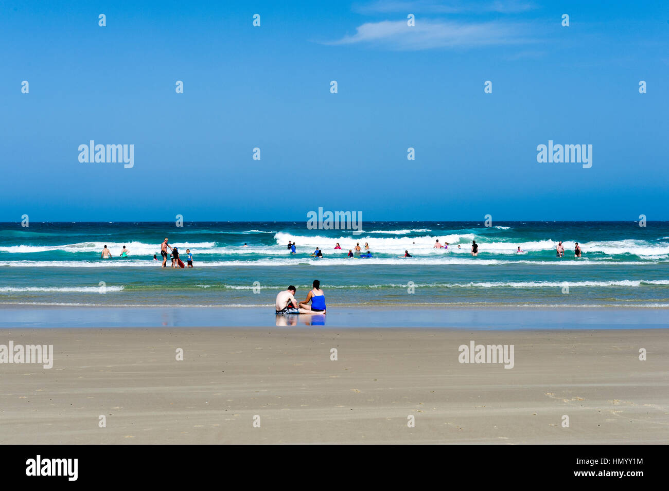 People playing on a wide beach at low tide Stock Photo - Alamy