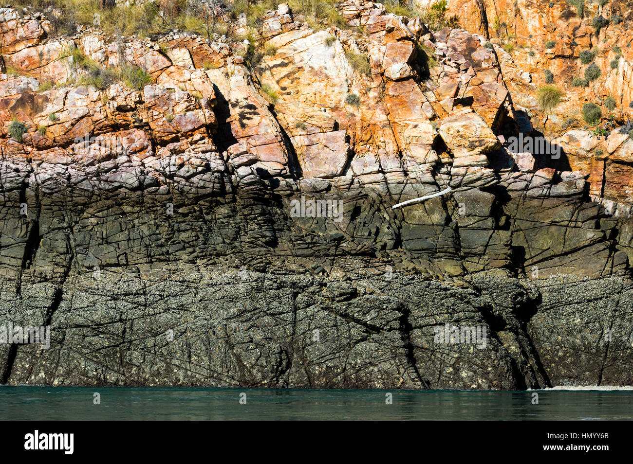 The hide tide mark and cyanobacteria stain on a sandstone cliff above ...