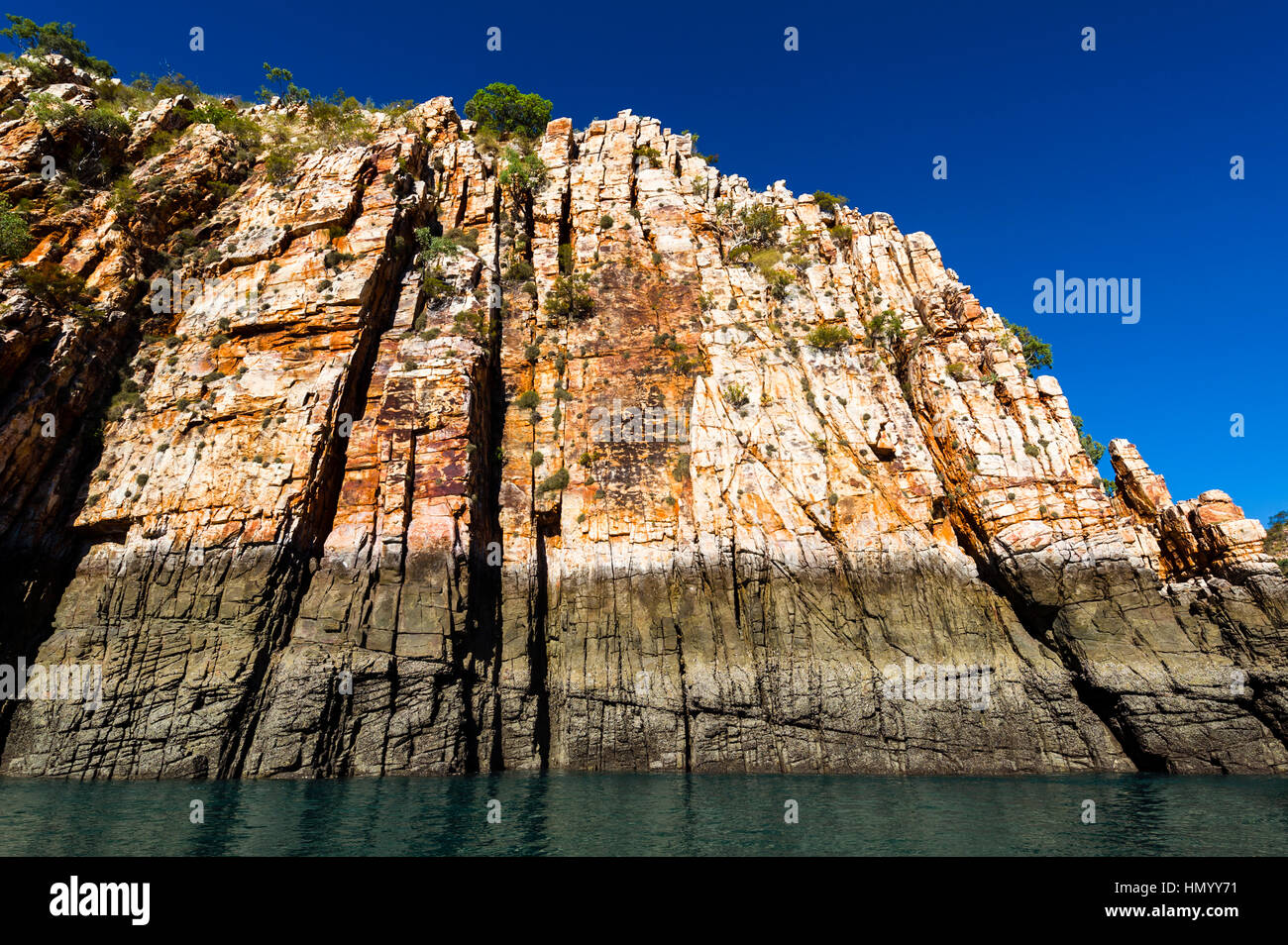 The hide tide mark and cyanobacteria stain on a sandstone cliff above ...
