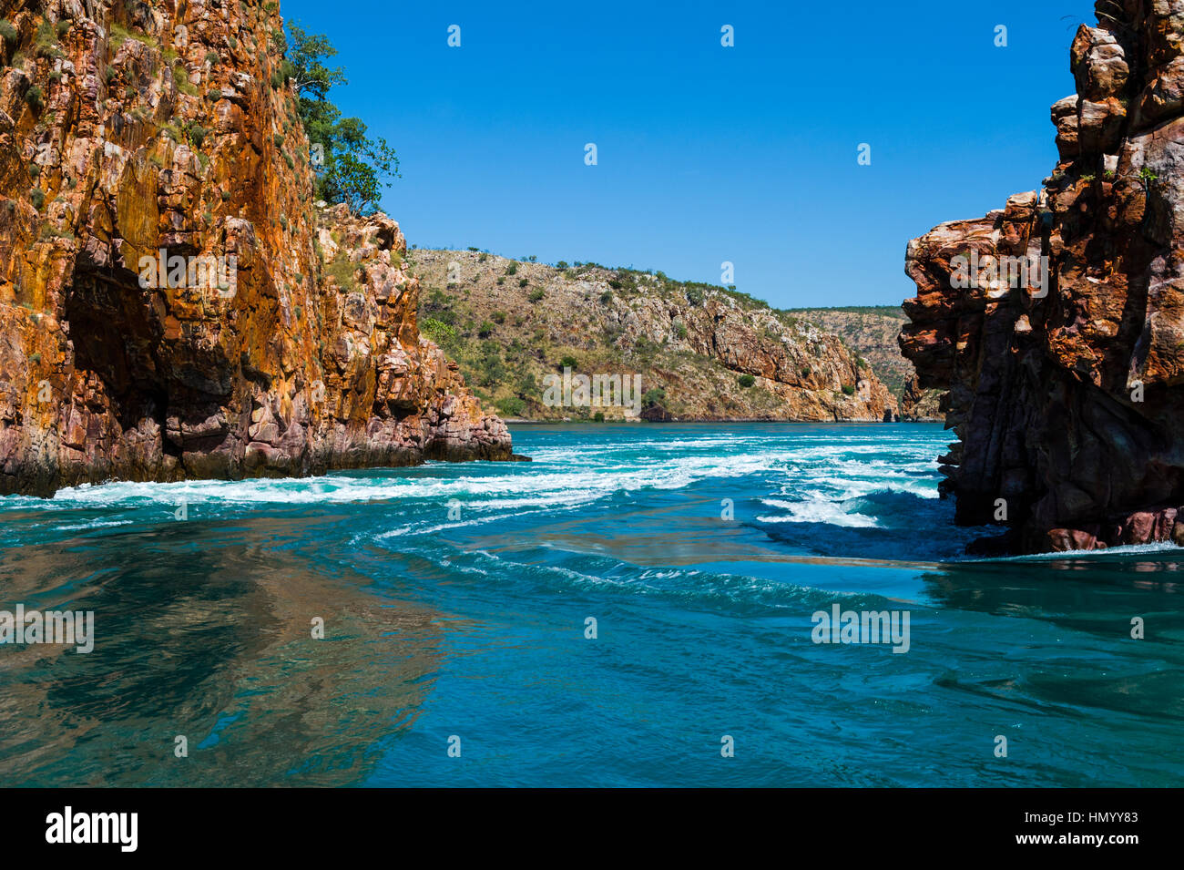 A fast moving tidal flow through a narrow gorge beneath the high tide ...