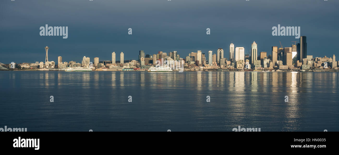 As the sun sets the buildings of the Seattle skyline are reflected in ...