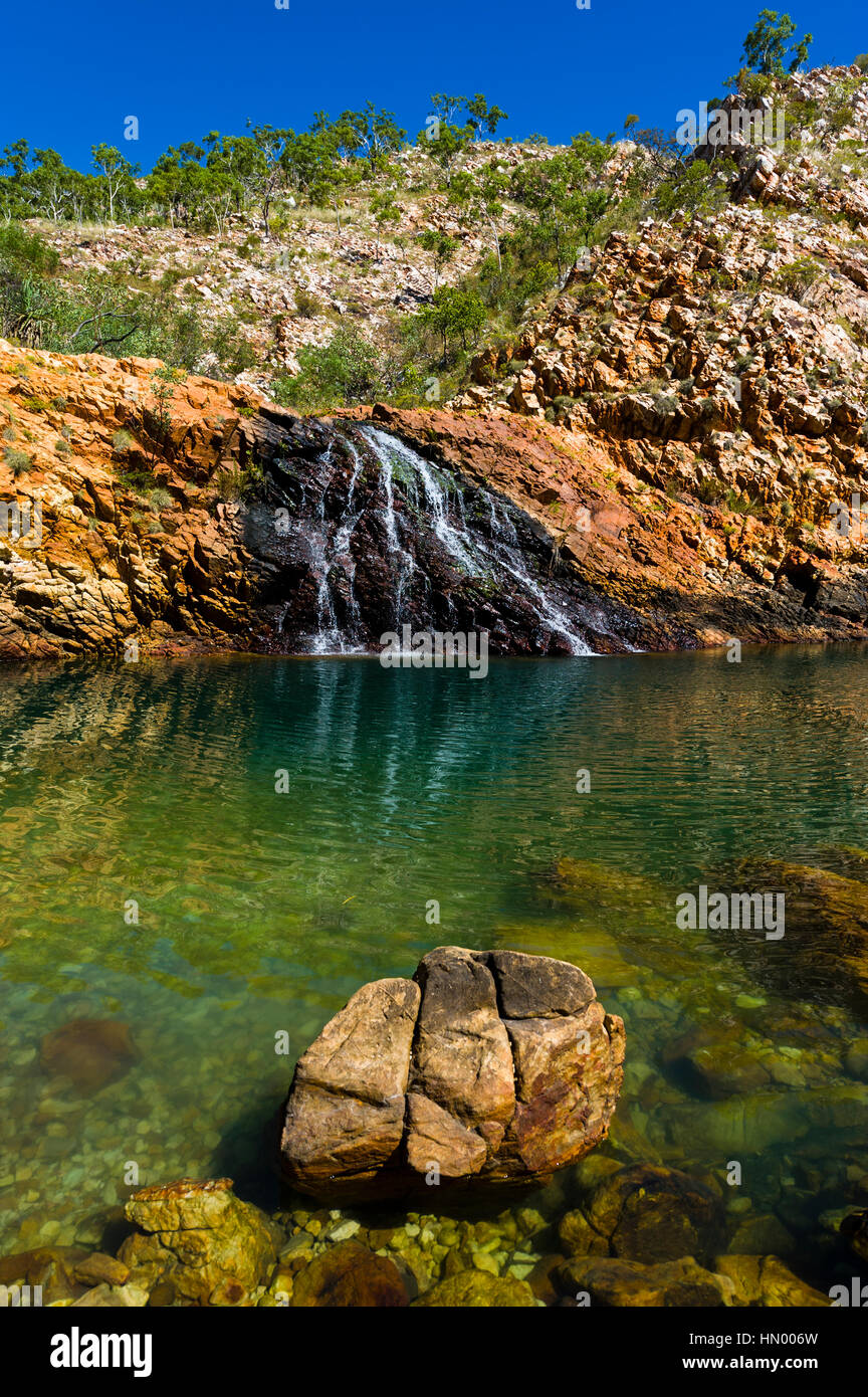 A small waterfall cascades into a sandstone gorge waterhole in the ...