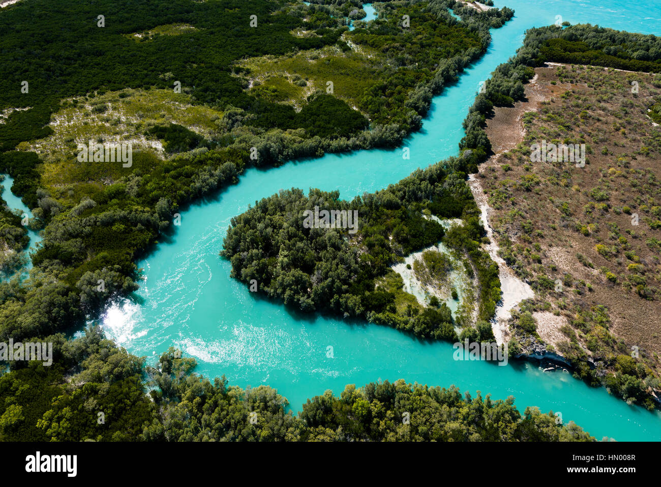 A turquoise tidal river winding it's way through mangroves in a tidal ...