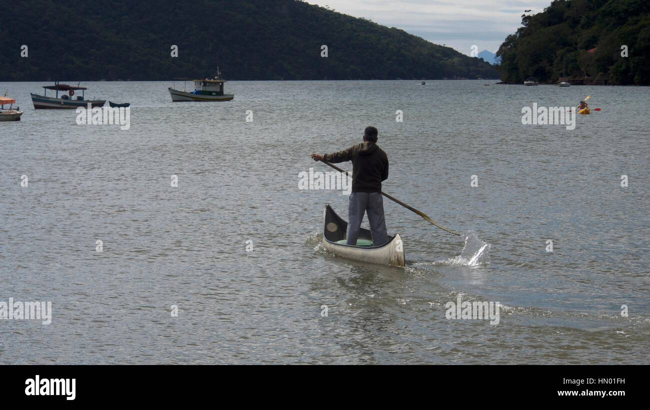 Man paddling canoe in the ocean Stock Photo - Alamy
