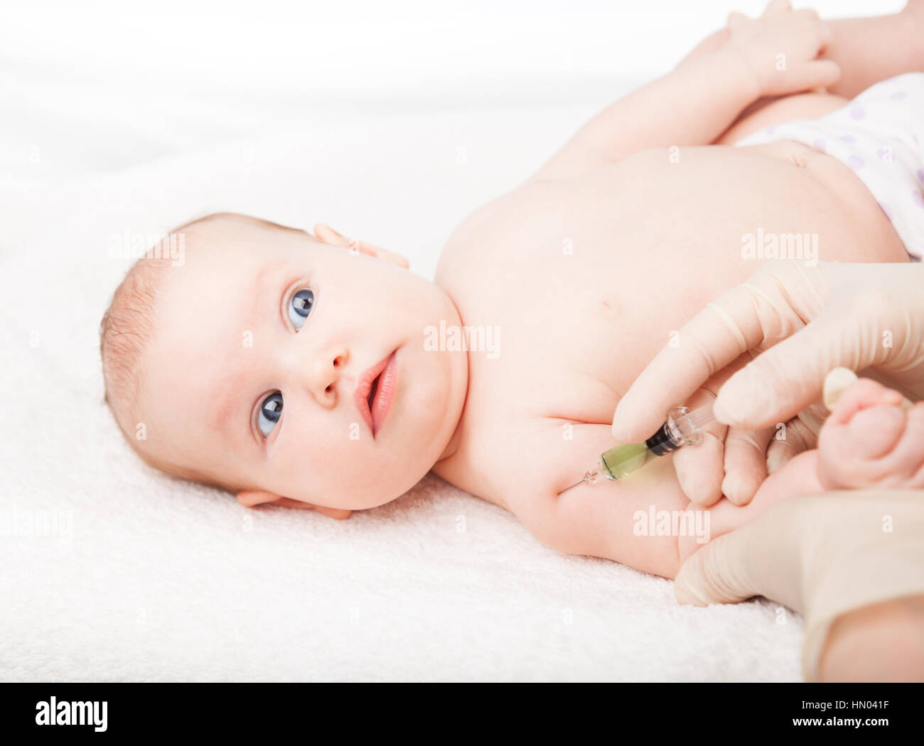 Pediatrician giving a three month baby girl intramuscular injection in ...