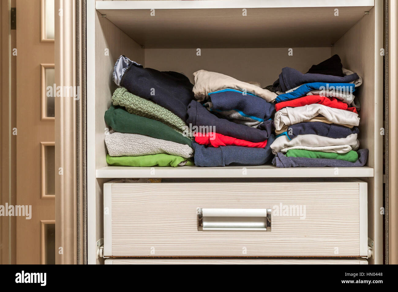 A stack of knitted warm woolen clothes in wardrobe close up Stock Photo ...