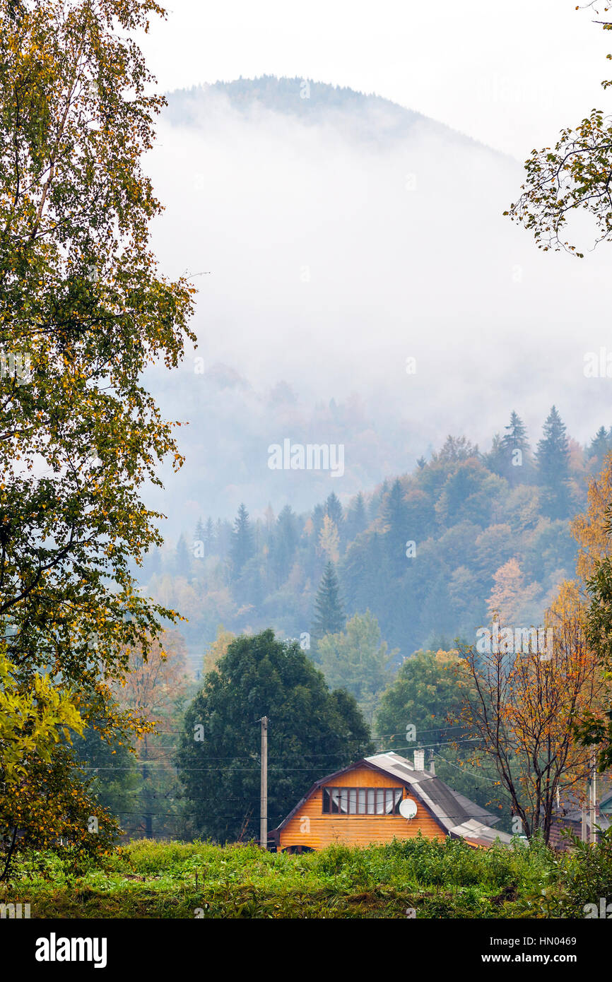 Lonely traditional countryside house near the mountain in misty rainy ...
