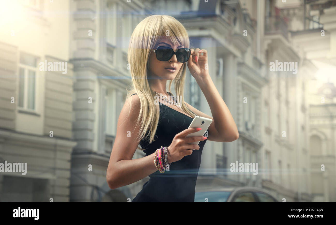 Girl with phone in sunglasses Stock Photo - Alamy