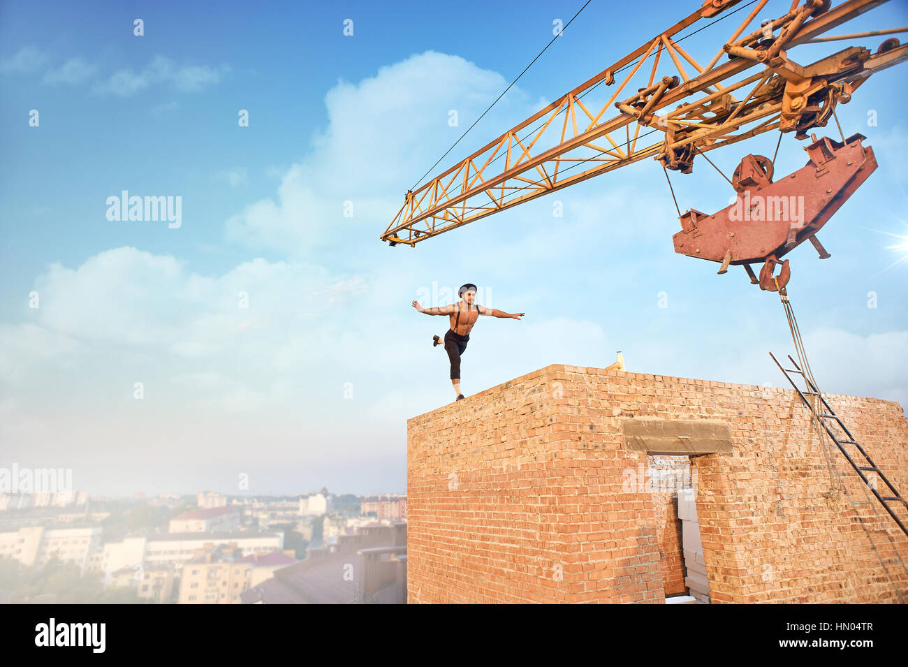 Athletic man doing exercise on high wall Stock Photo - Alamy