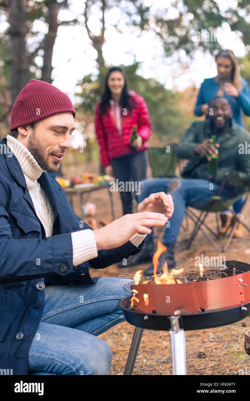 Man kindling fire on grill Stock Photo - Alamy