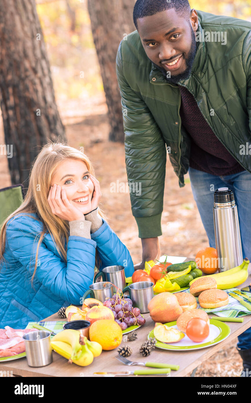 Smiling friends having fun in campsite Stock Photo - Alamy
