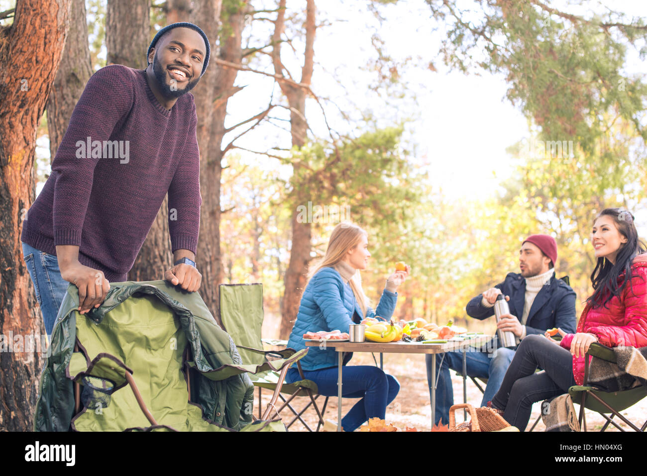 Smiling friends having fun in campsite Stock Photo - Alamy