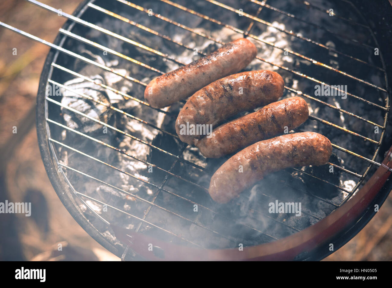 Grilling sausages on barbecue grill Stock Photo - Alamy