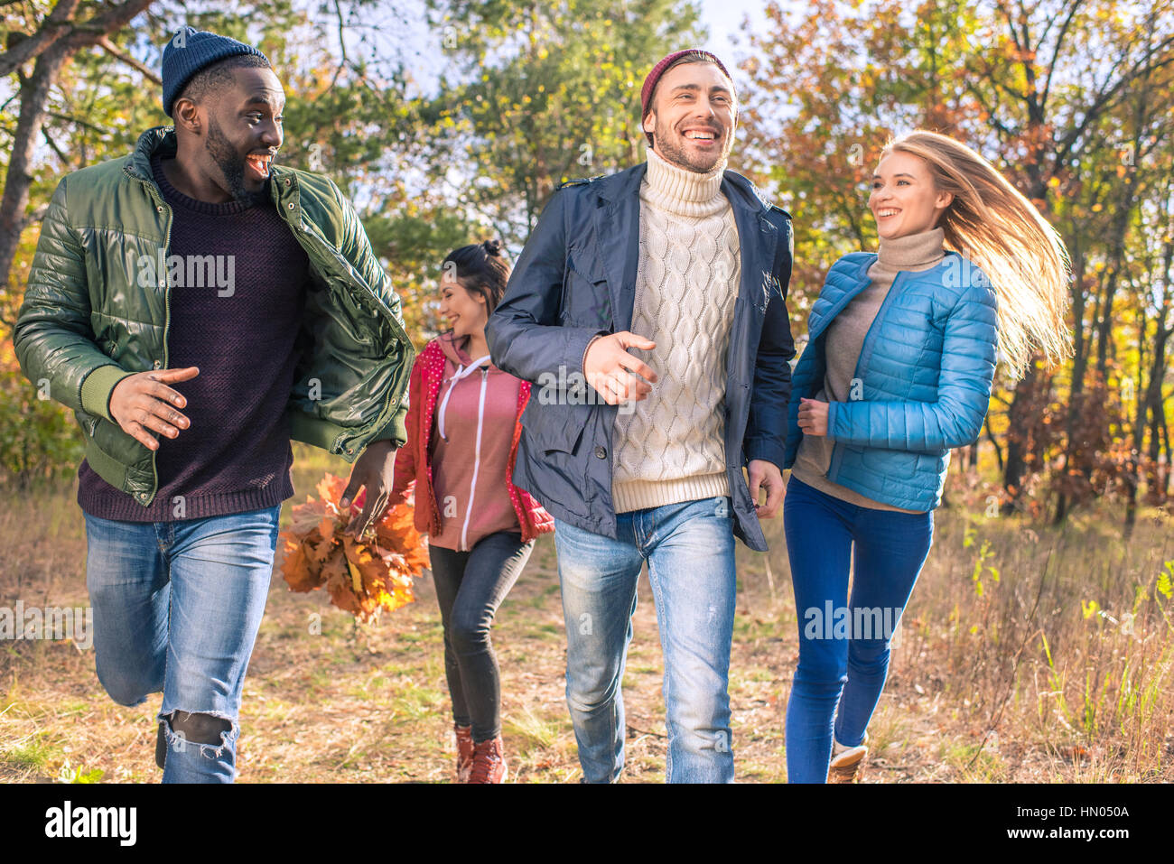 Happy friends walking in autumn park Stock Photo - Alamy