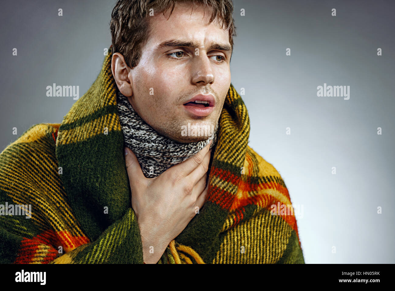 Unhappy man with sore throat. Sick man wrapped in blanket suffering ...