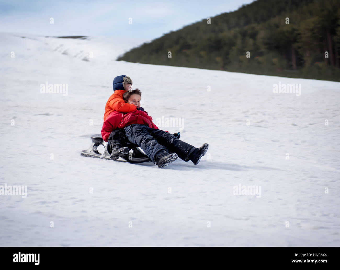 Happy friends in winter sledding Stock Photo - Alamy