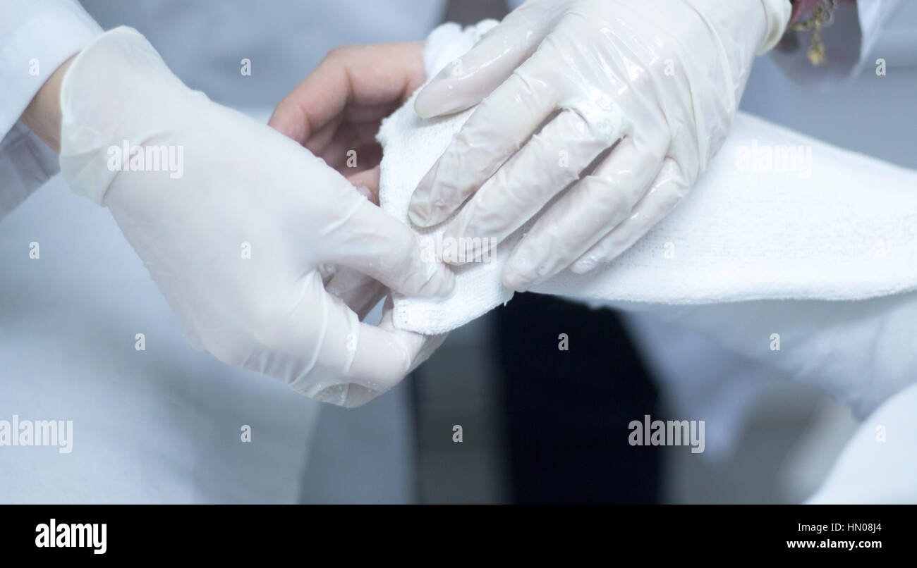Doctor applying a plaster cast and bandages to patient forearm and ...