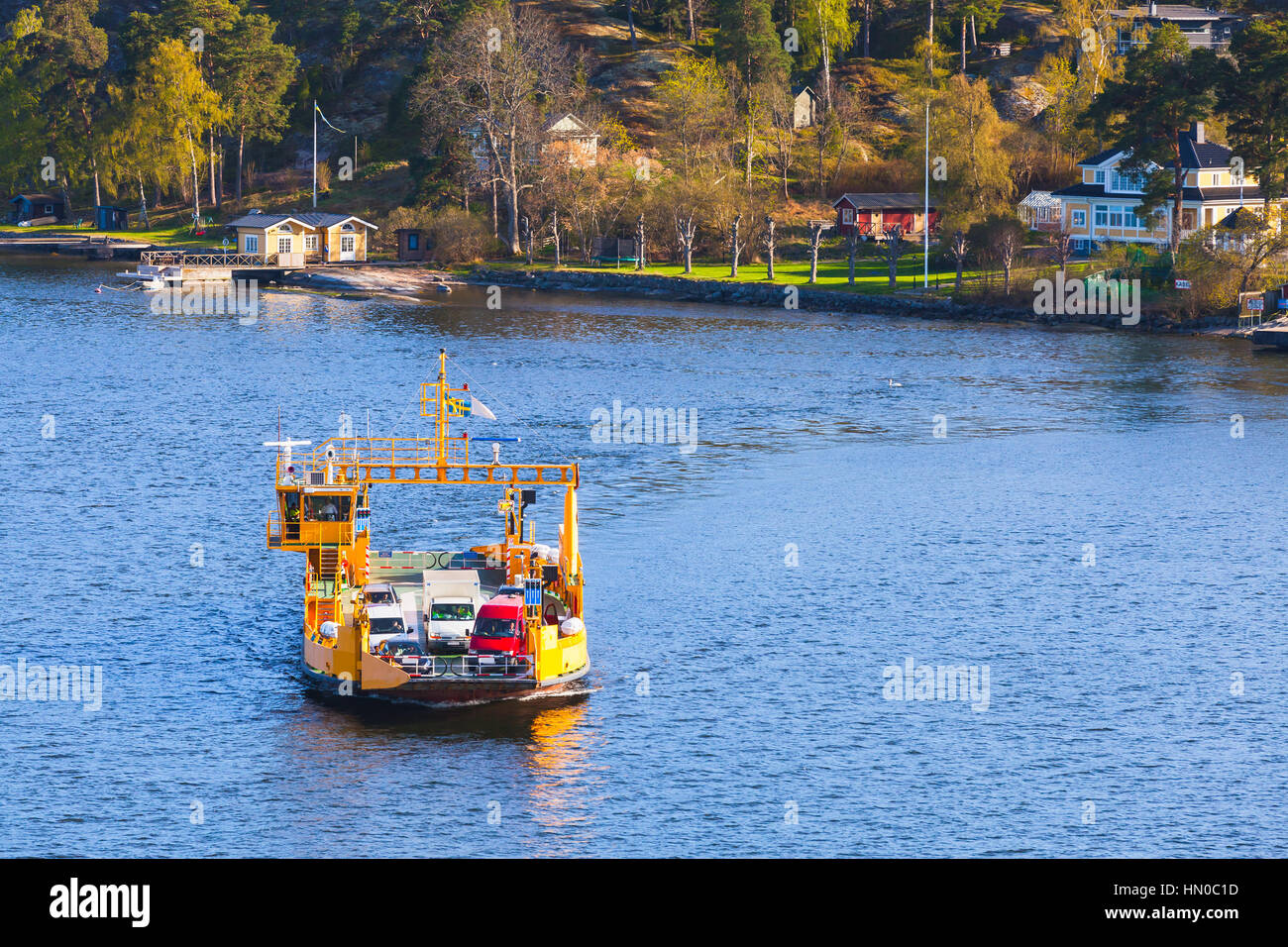 Yellow Ro-Ro cargo ship crossing the bay. Small ferry line near ...
