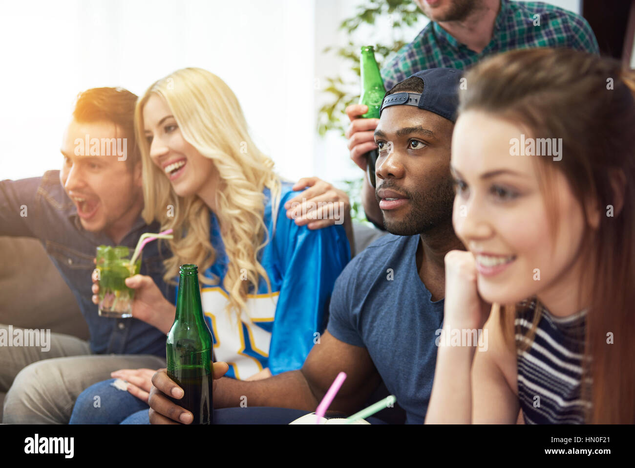 Group of young people watching soccer match Stock Photo - Alamy