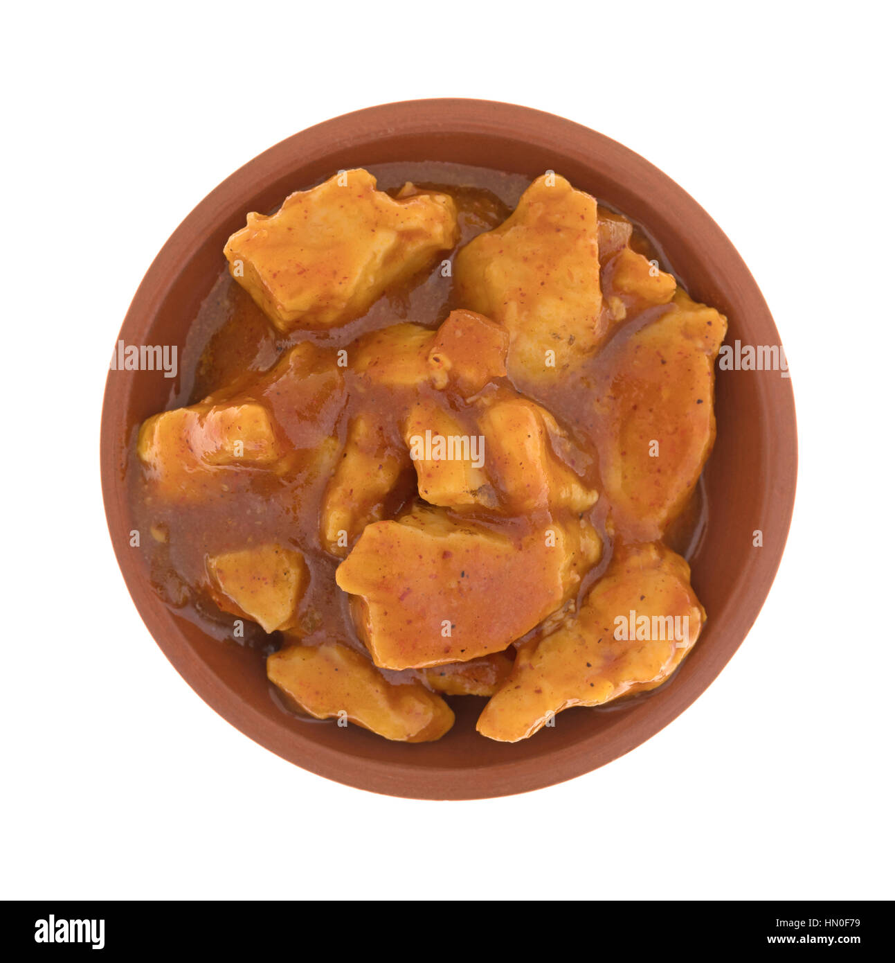 Top view of a small bowl filled with chunks of chicken in a thick ...