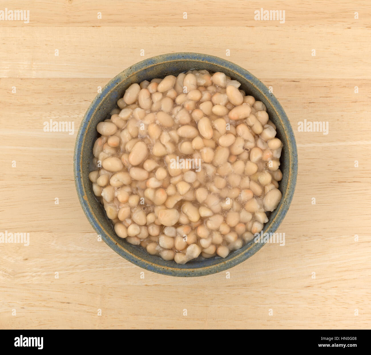 Top view of a serving of organic navy beans in an old stoneware bowl ...
