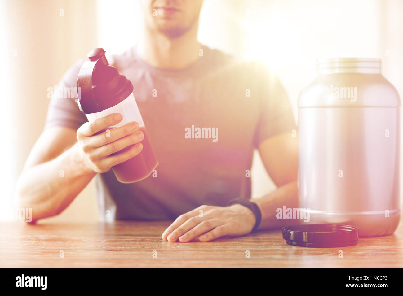 close up of man with protein shake bottle and jar Stock Photo - Alamy