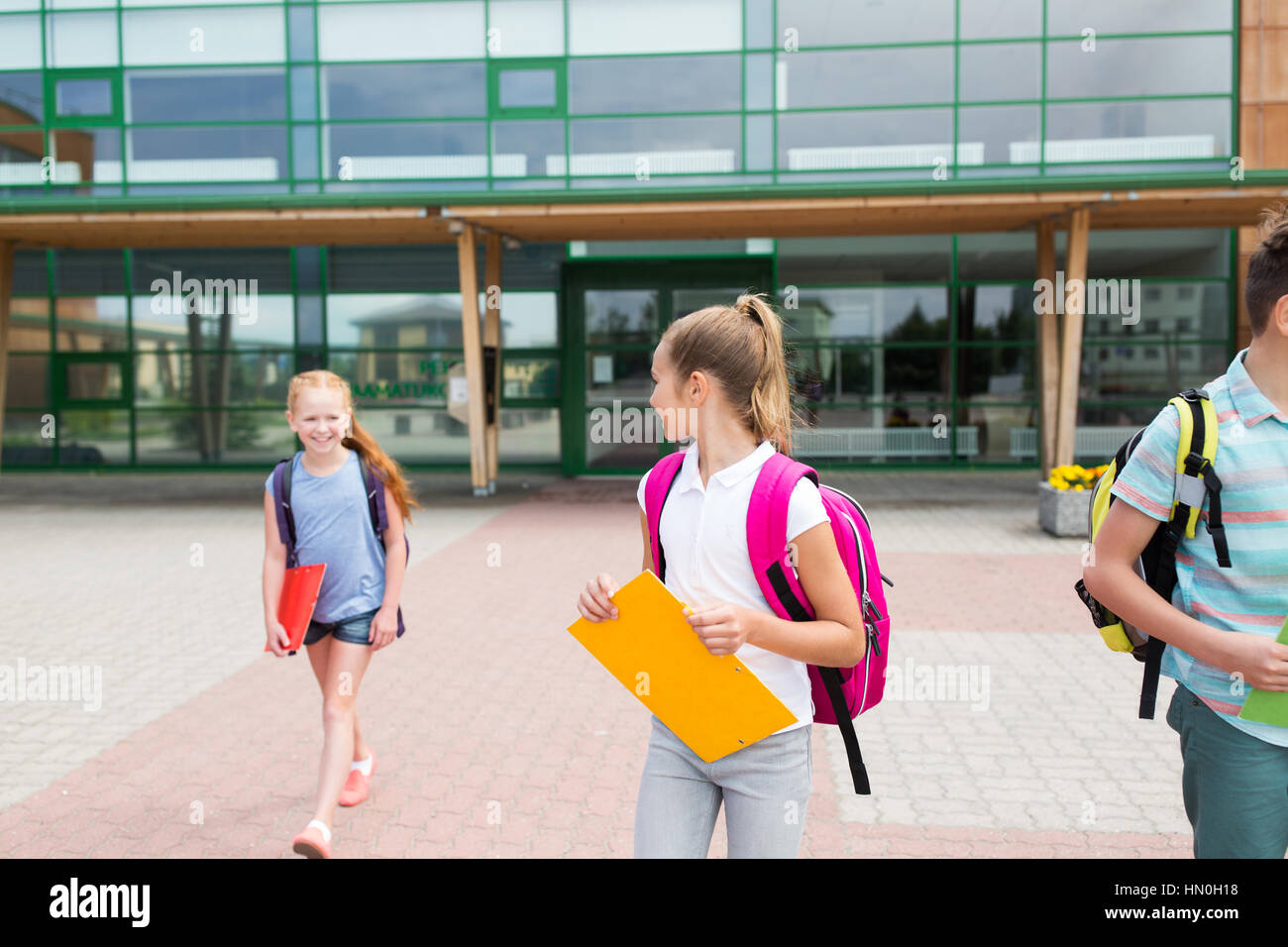 happy elementary school students with folders Stock Photo - Alamy