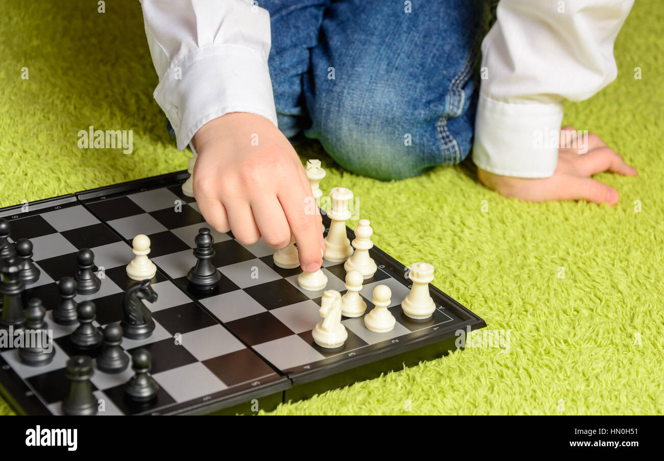 child playing chess sitting on the carpet Stock Photo - Alamy