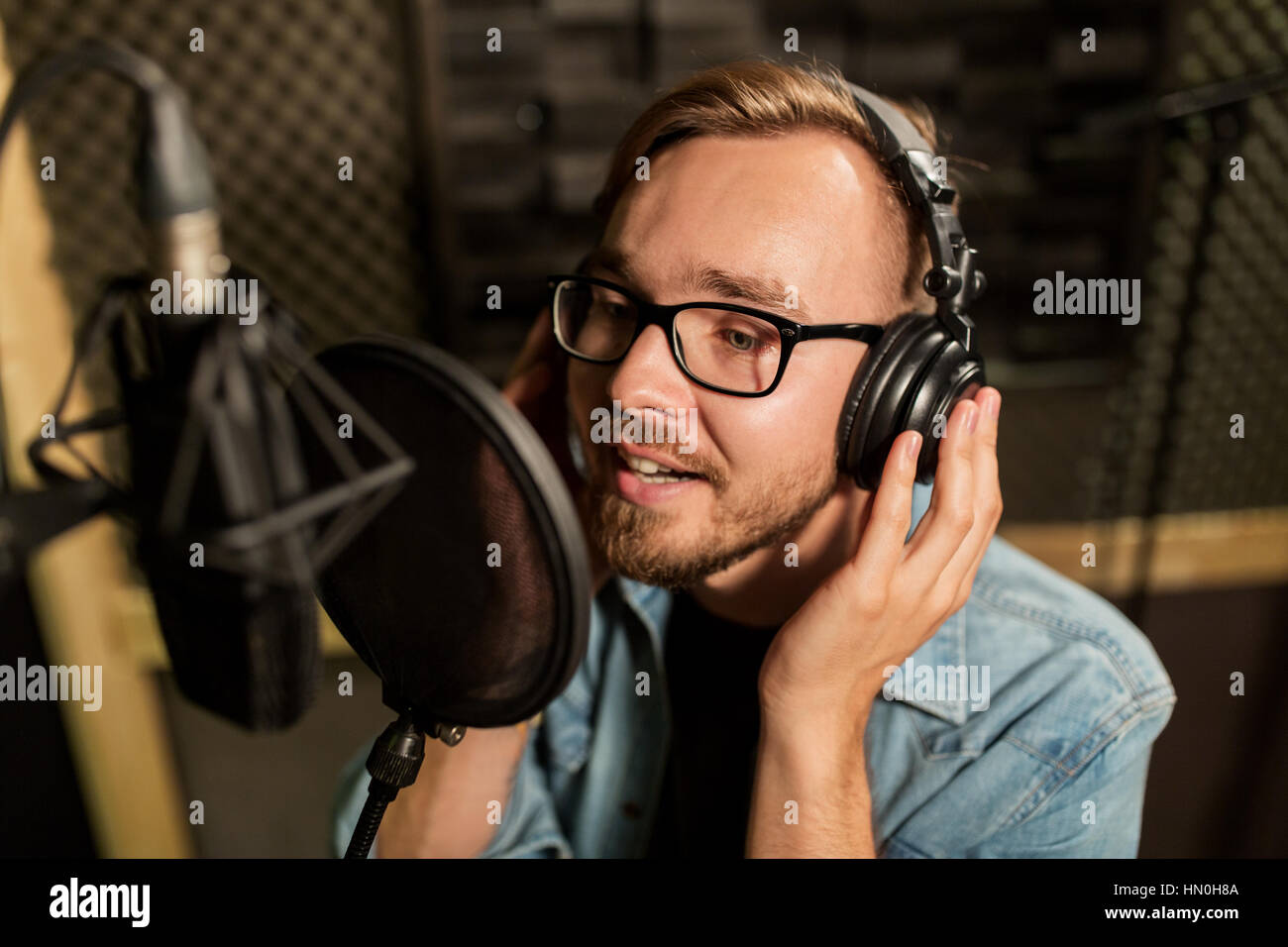 man with headphones singing at recording studio Stock Photo - Alamy
