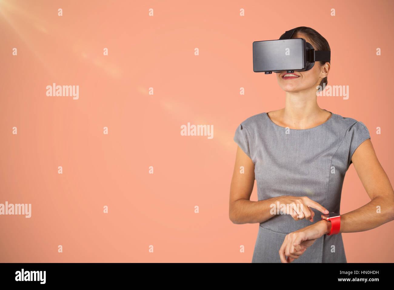 Smiling young woman standing while using virtual video glasses against ...