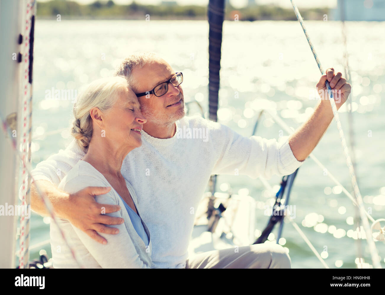 senior couple hugging on sail boat or yacht in sea Stock Photo - Alamy