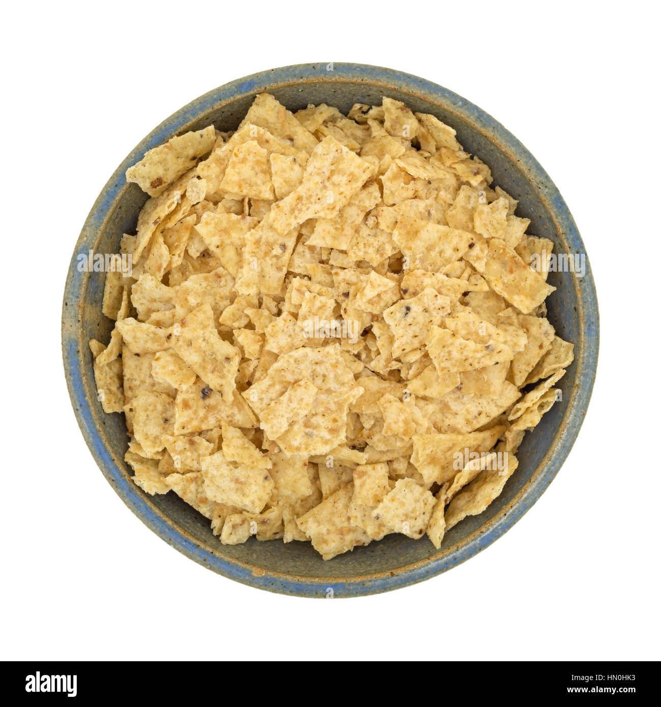 Top view of broken tortilla chips in an old stoneware bowl isolated on ...
