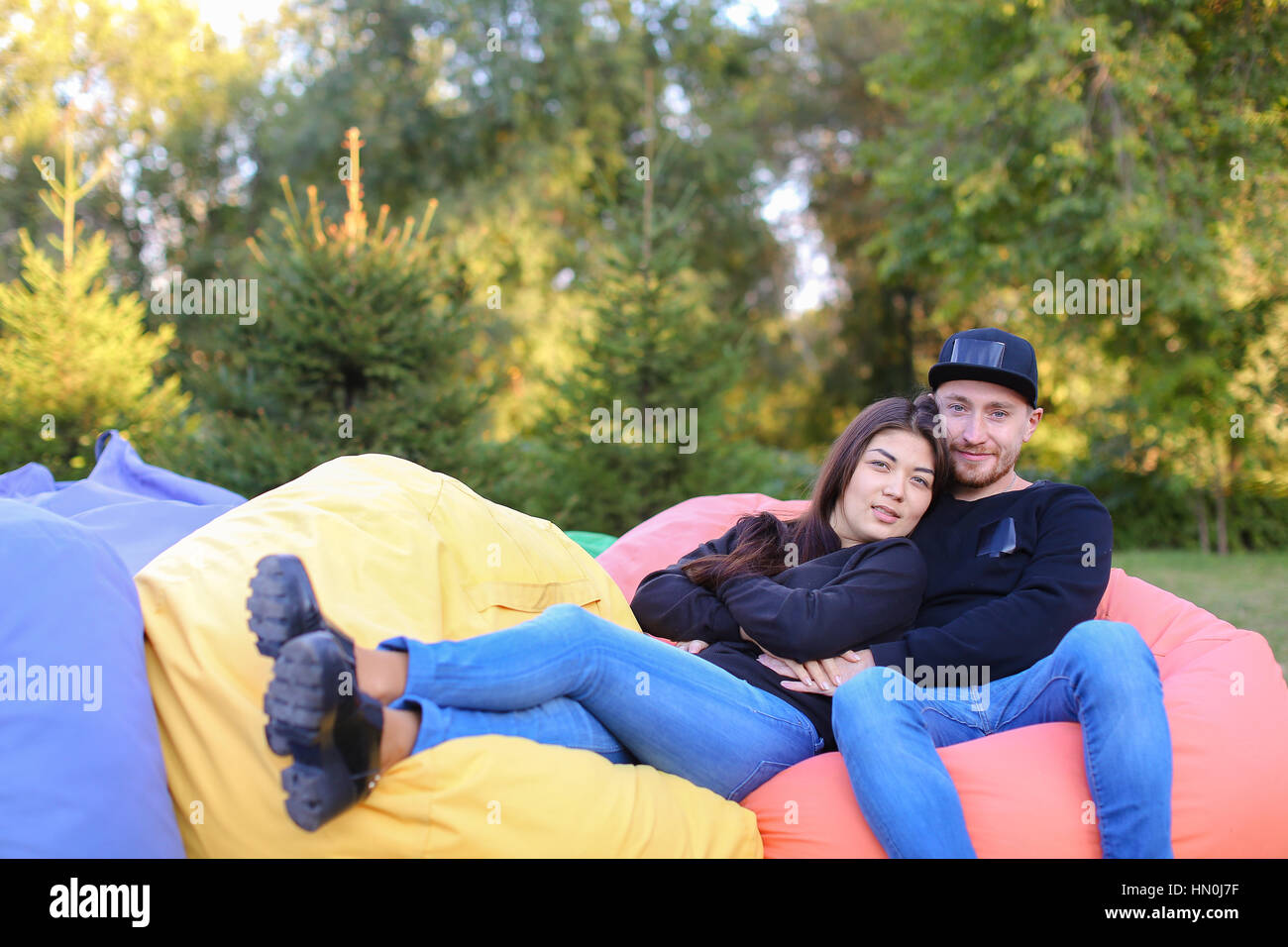 Pair of lovers of young attractive people sitting in soft yellow and ...