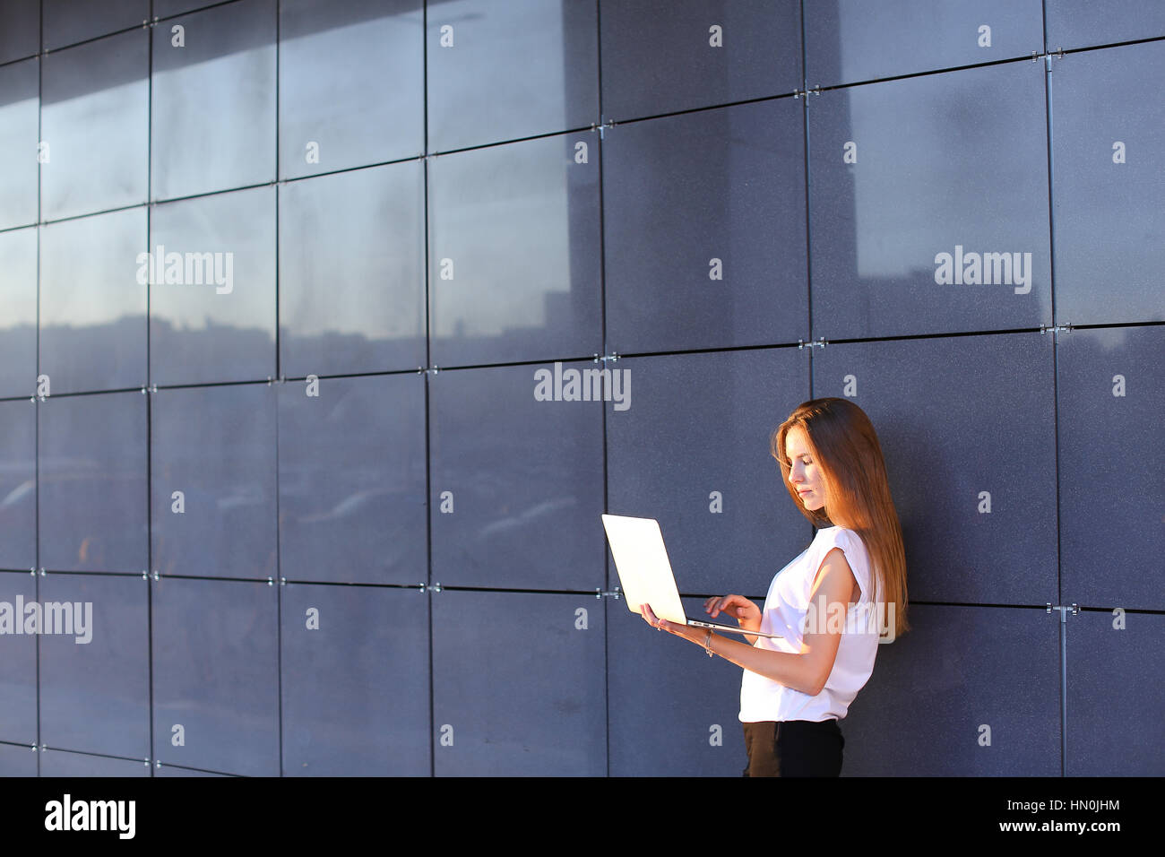 Young successful woman entrepreneur girl keeps in hands computer and ...
