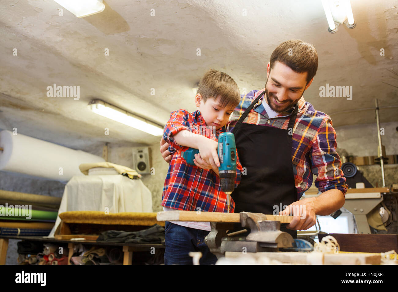 father and son with drill working at workshop Stock Photo - Alamy