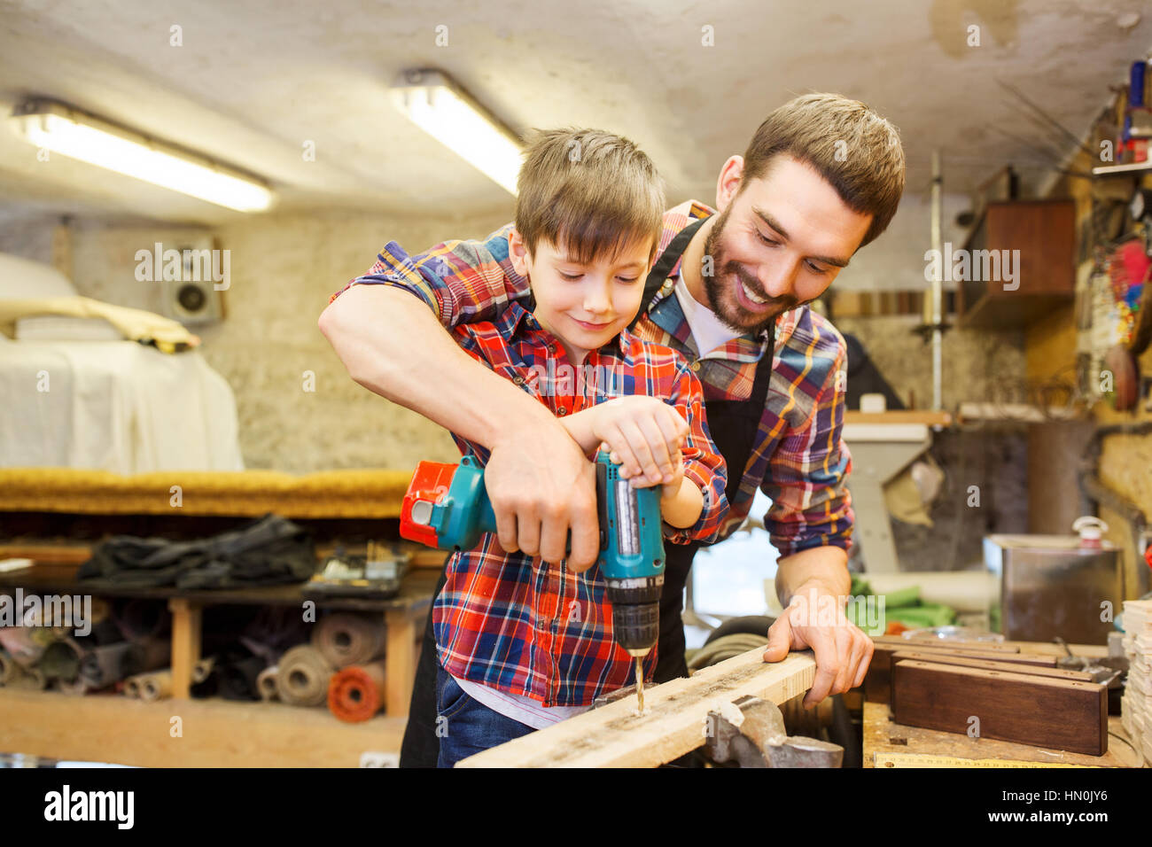 father and son with drill working at workshop Stock Photo - Alamy