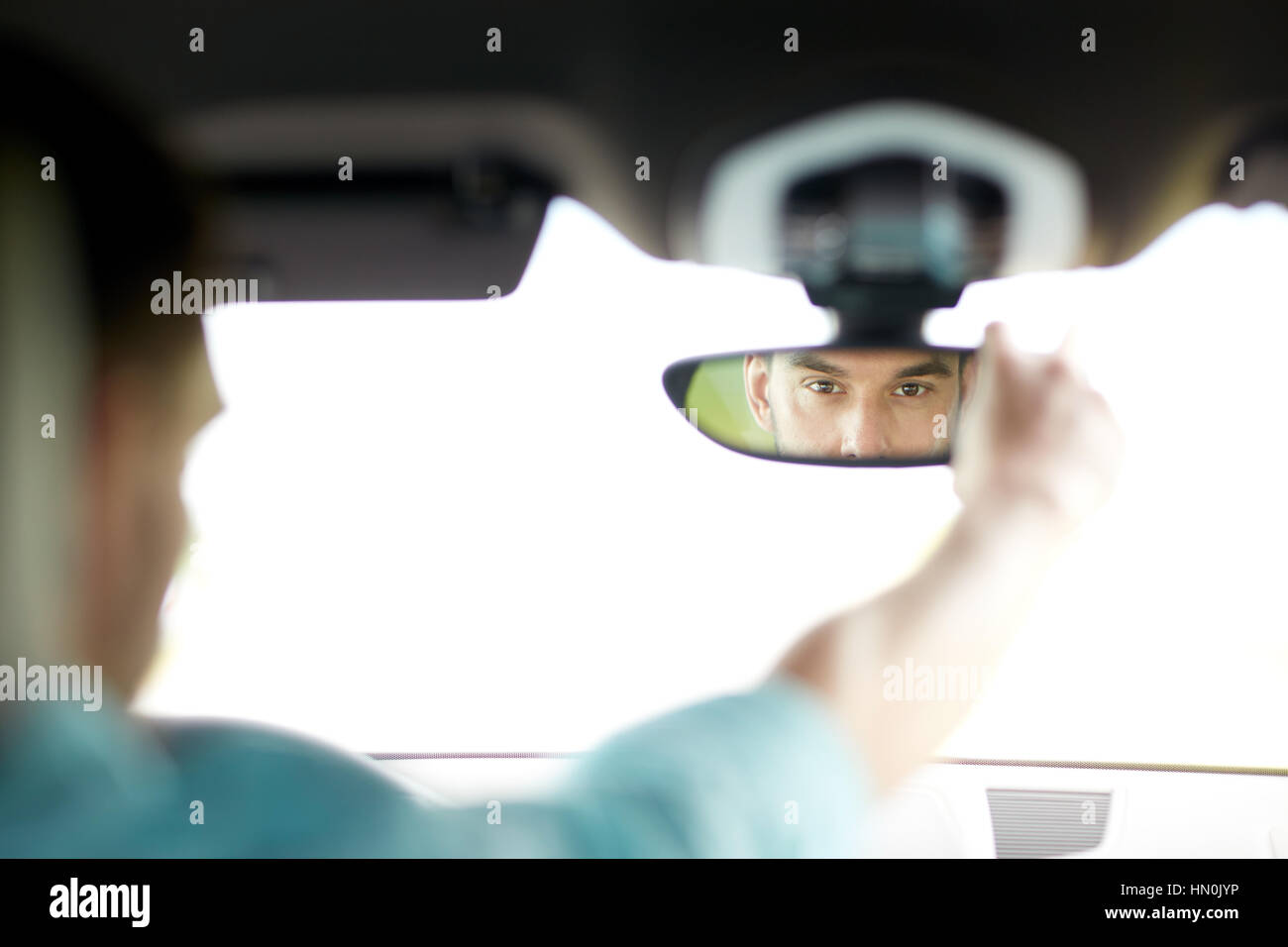 man driving car adjusting rearview mirror Stock Photo - Alamy