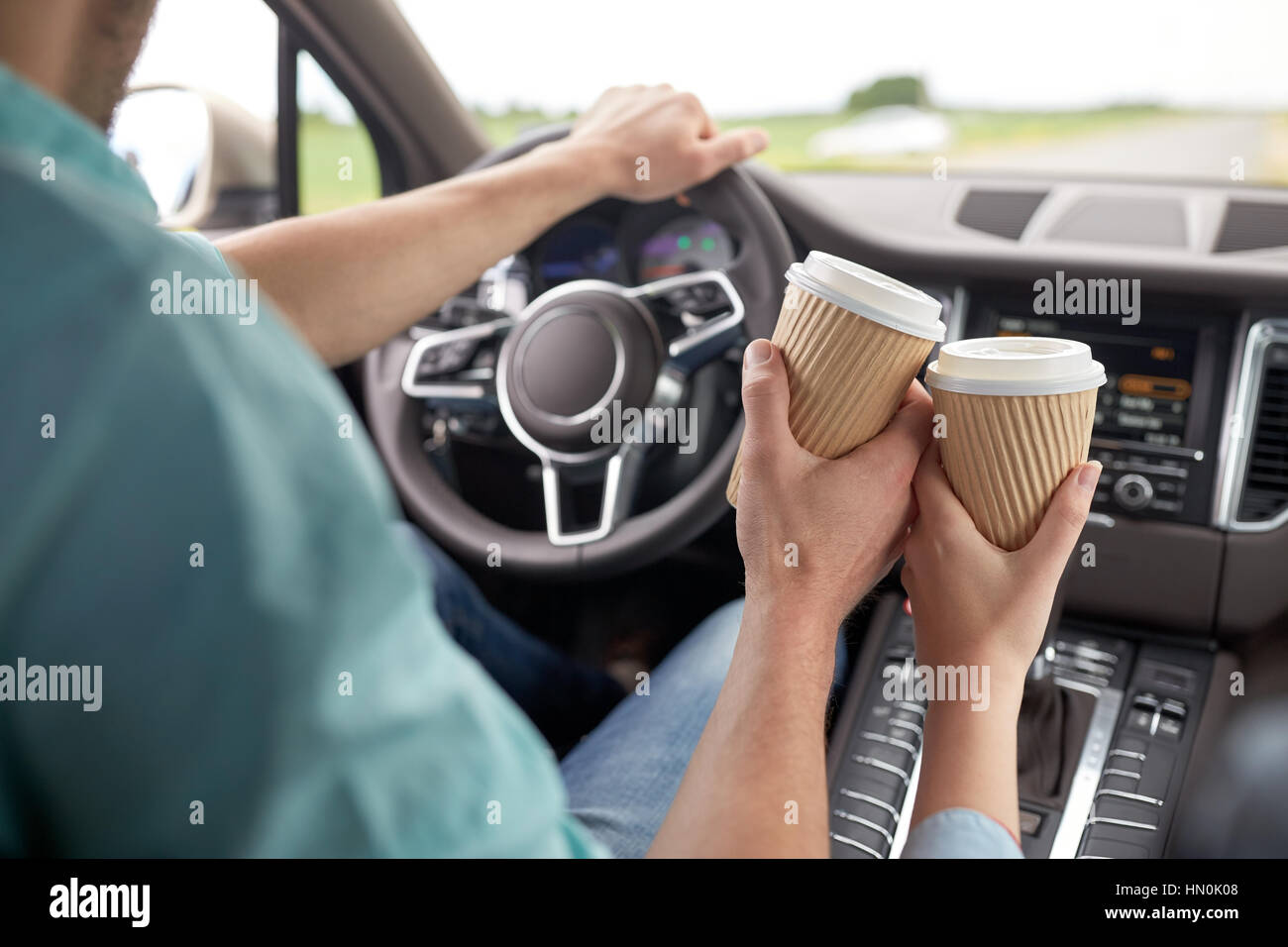 close up of couple driving in car with coffee cups Stock Photo - Alamy