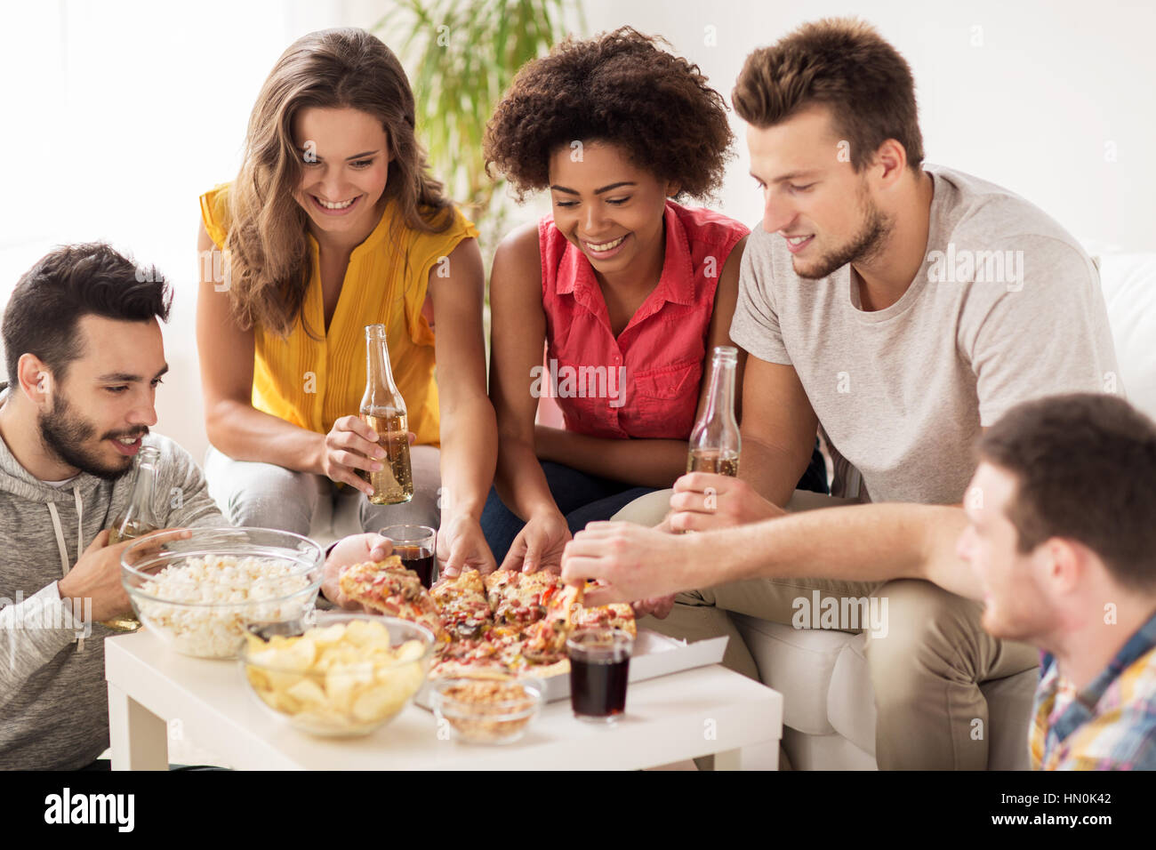 happy friends with drinks eating pizza at home Stock Photo - Alamy