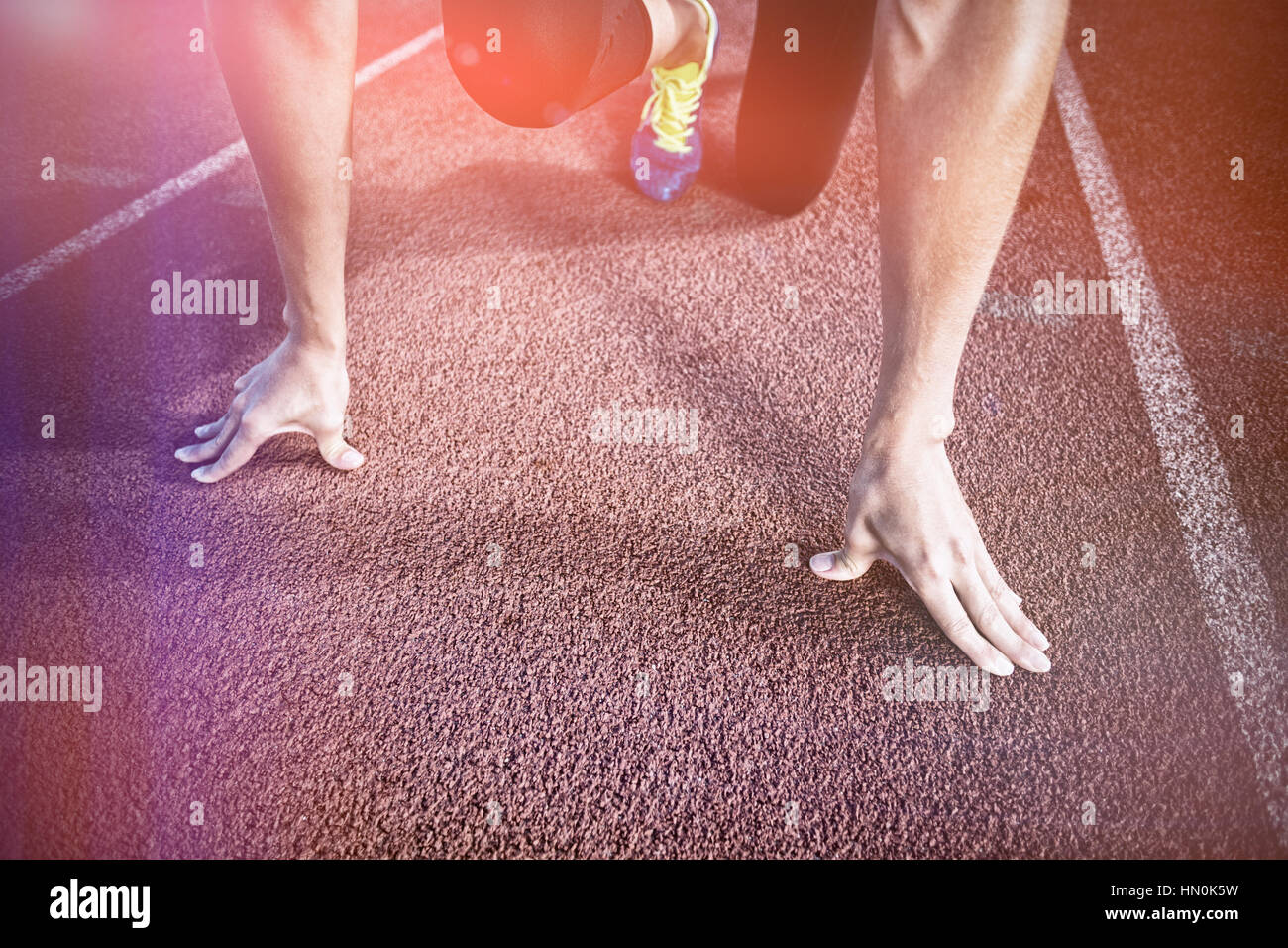 Female athlete in ready to run position on running track Stock Photo ...