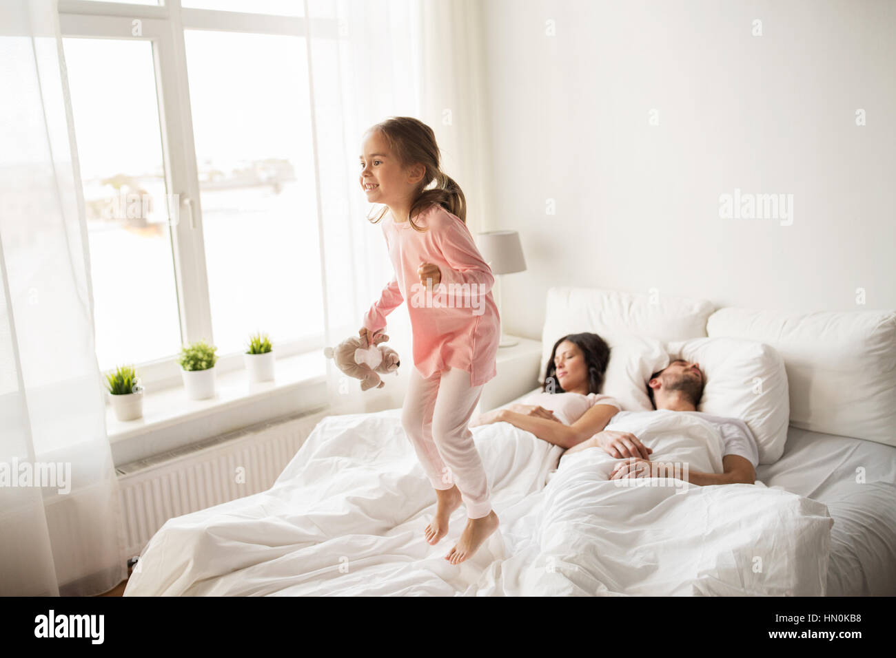 Child sleeping in bed with parents hi-res stock photography and images ...