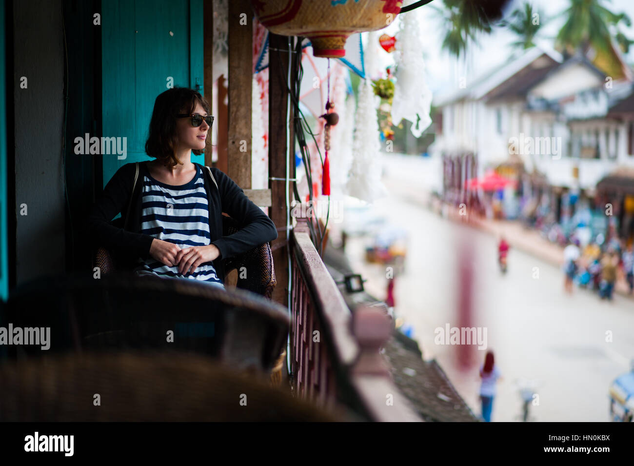 Caucasian woman enjoying the view from a cafe balcony in Luang Prabang ...