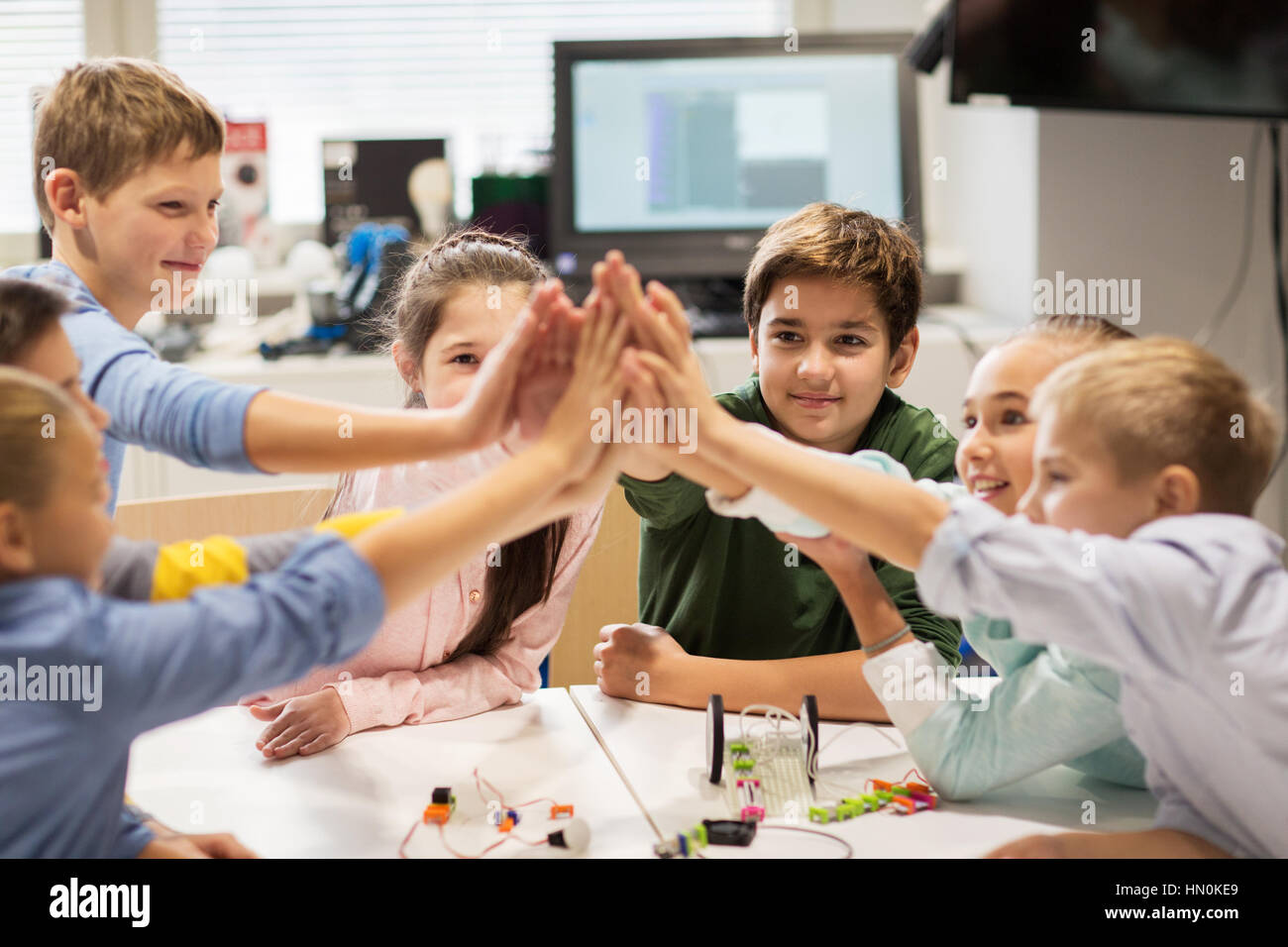 happy children making high five at robotics school Stock Photo - Alamy