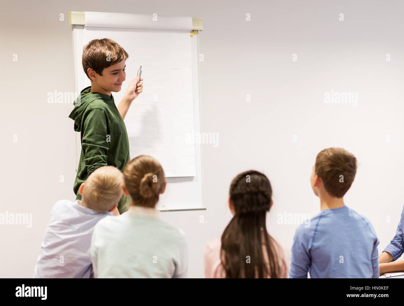 student boy with marker writing on flip board Stock Photo - Alamy