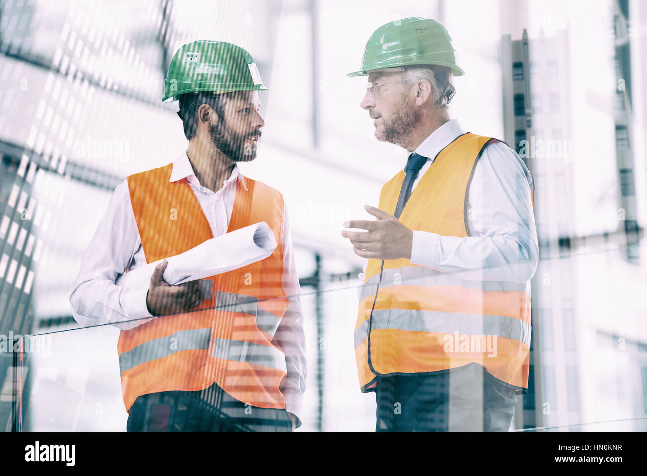View of modern office building against architects talking with each ...