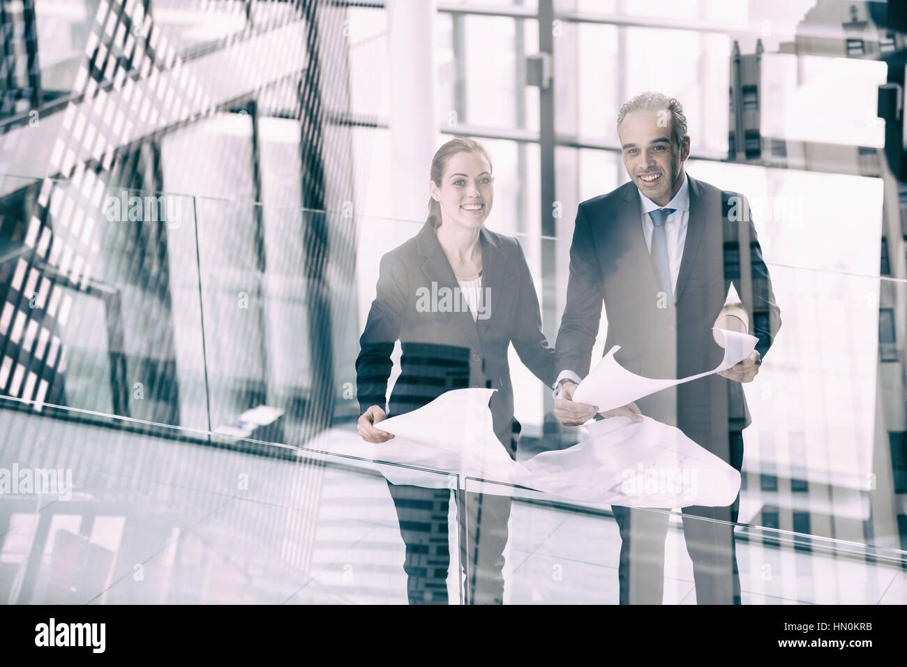 View of modern office building against portrait of business colleagues ...