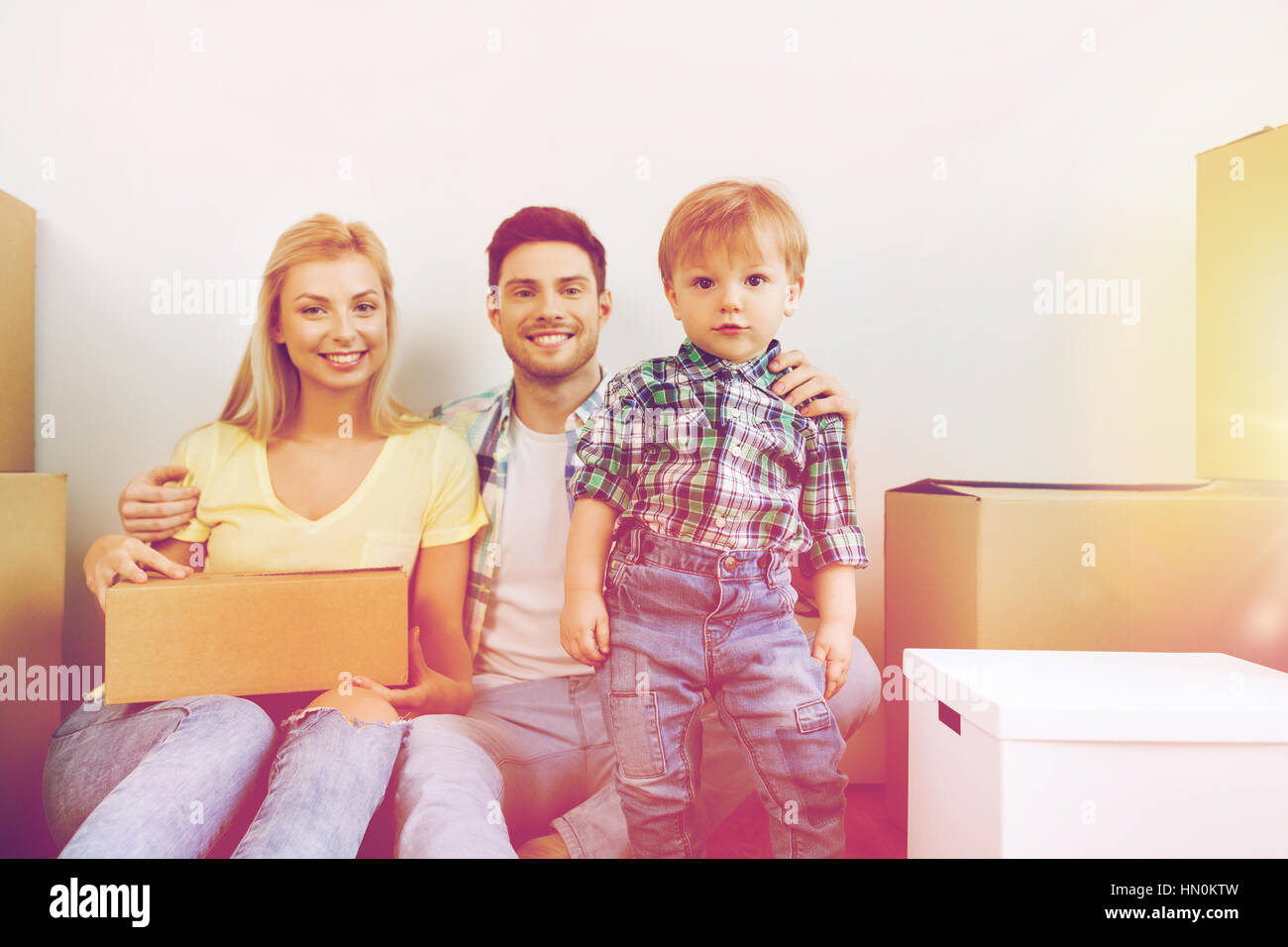 happy family with boxes moving to new home Stock Photo - Alamy