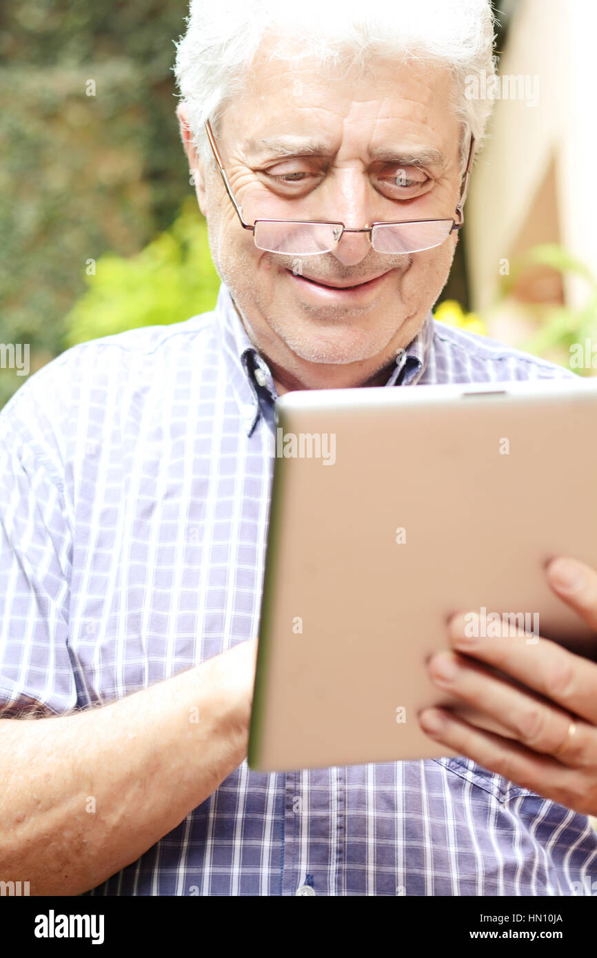 Portrait of an old man using digital tablet. Outdoors Stock Photo - Alamy