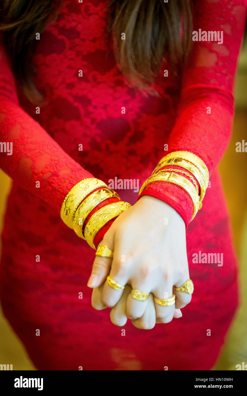 Chinese wedding gold jewelry on wrist and red dress Stock Photo - Alamy